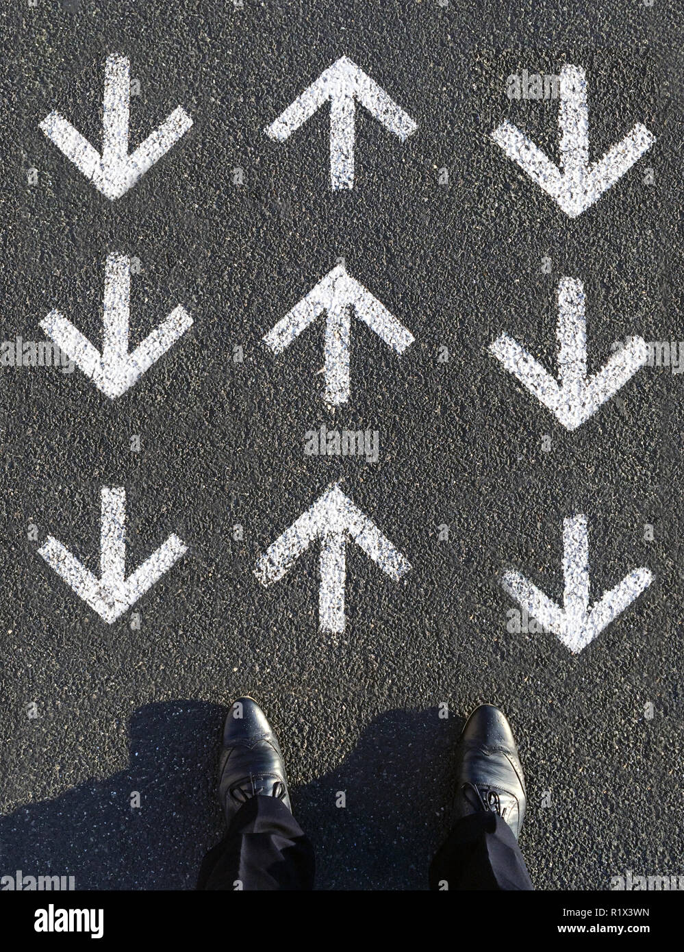 Finding your own way: Man standing in front of arrow symbols leading ...