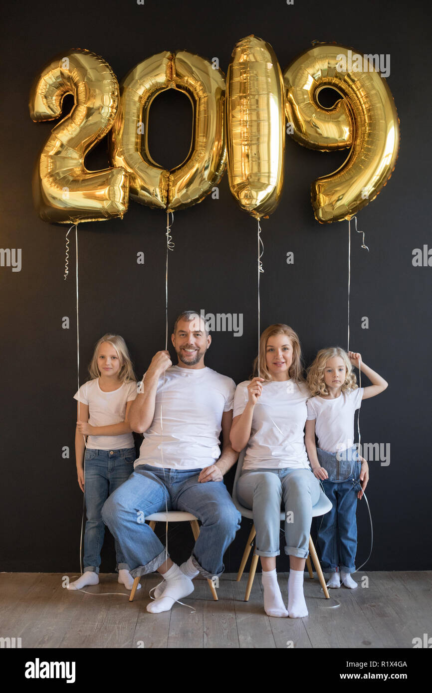Happy family holding sign 2019 made of golden balloons for new year on ...