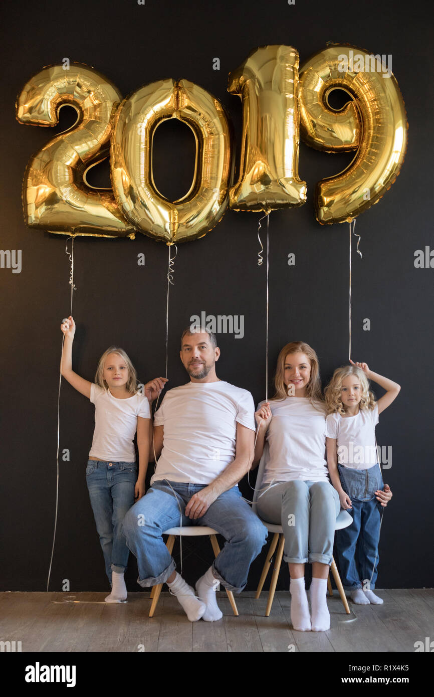 Happy family holding sign 2019 made of golden balloons for new year on ...