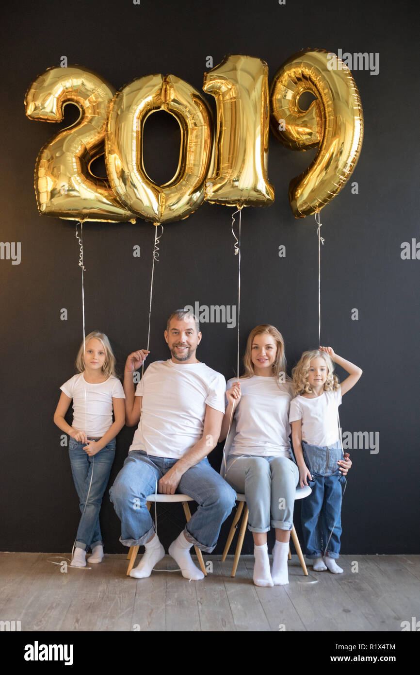 Happy family holding sign 2019 made of golden balloons for new year on ...
