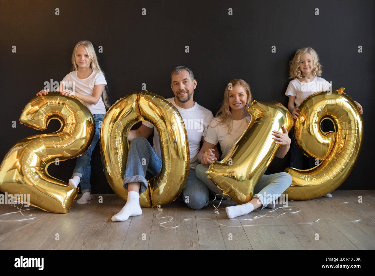 Happy family holding sign 2019 made of golden balloons for new year on ...