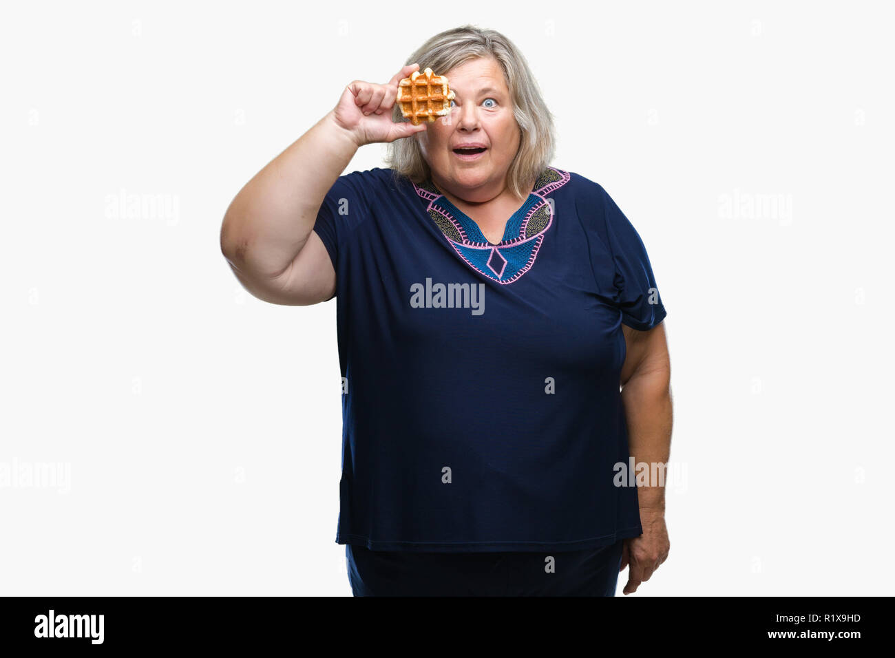 Senior plus size caucasian woman eating waffle over isolated background ...