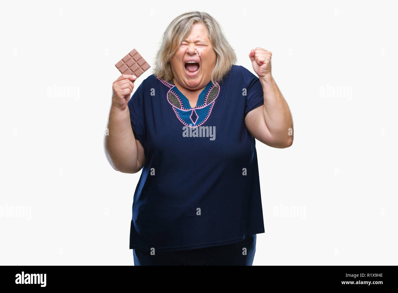 Senior plus size caucasian woman eating chocolate bar over isolated ...
