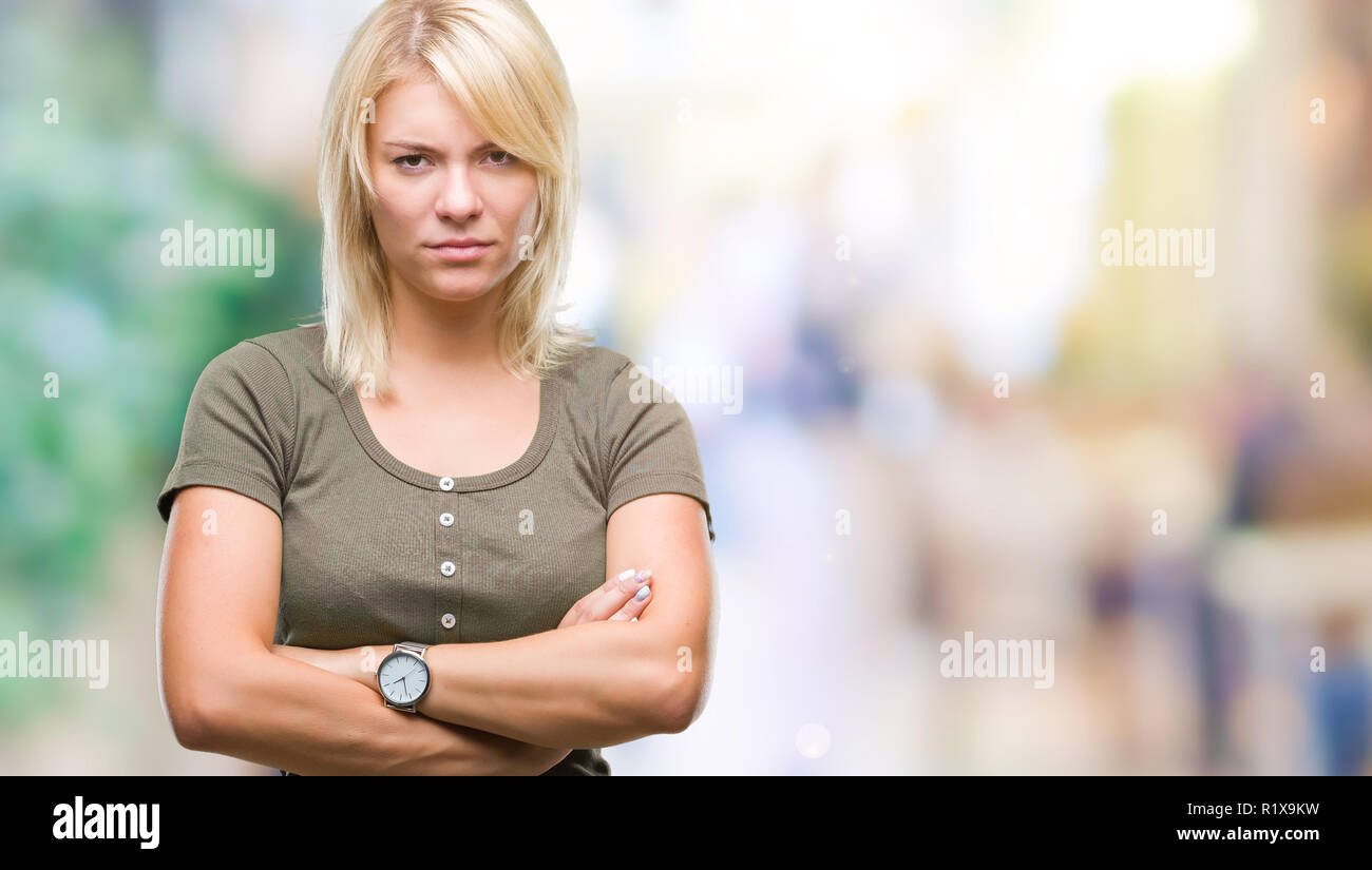 Young beautiful blonde woman over isolated background skeptic and ...