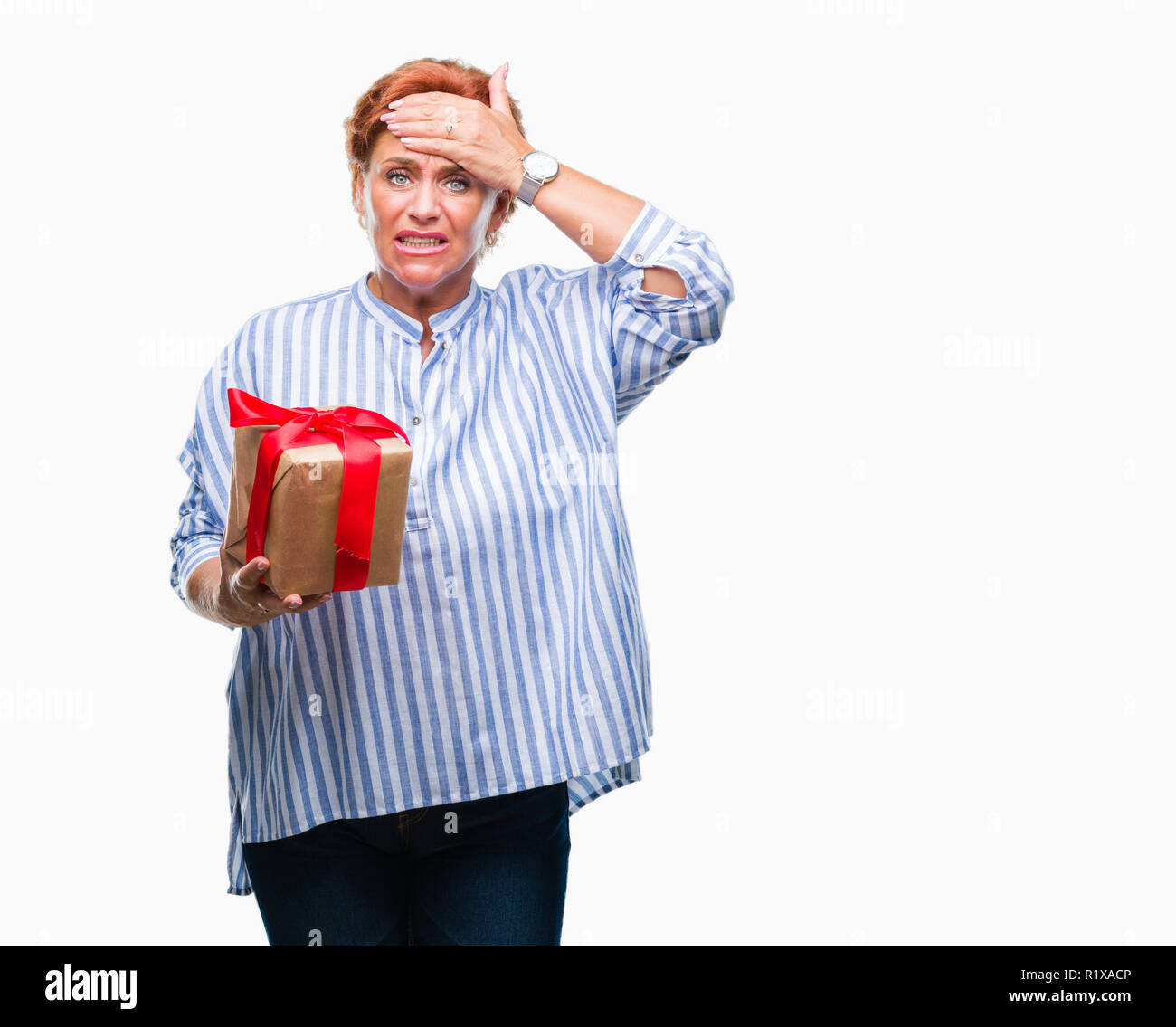 Senior caucasian woman holding gift over isolated background stressed ...