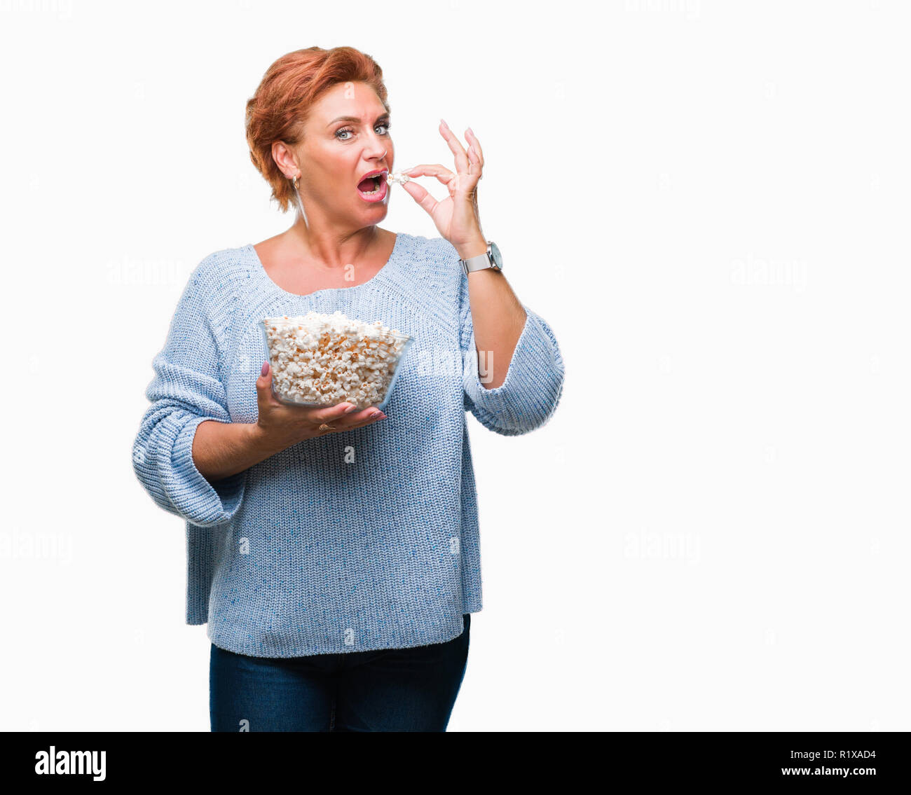 Atrractive Senior Caucasian Redhead Woman Eating Popcorn Over Isolated