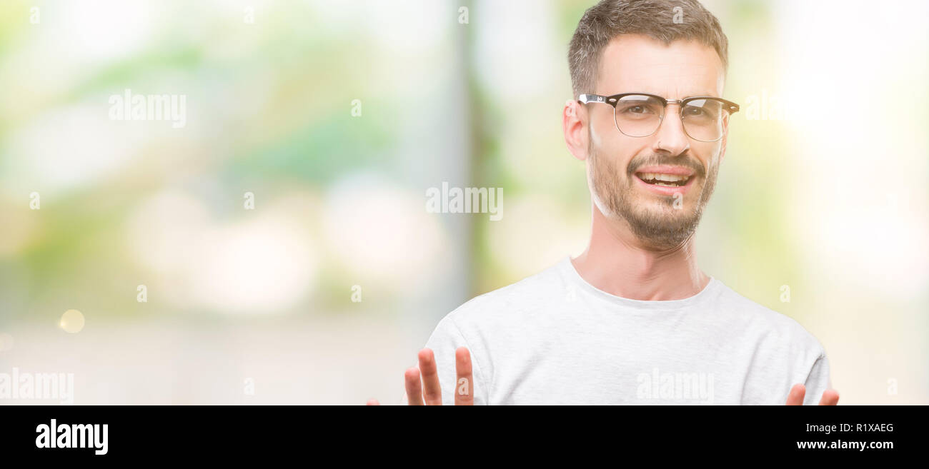 Young tattooed adult man afraid and terrified with fear expression stop ...