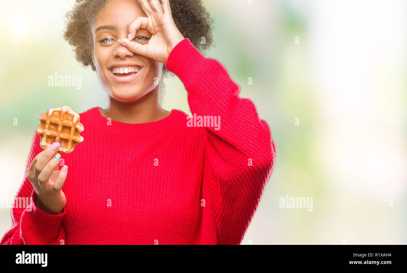 Young beautiful afro american woman eating waffle over isolated ...