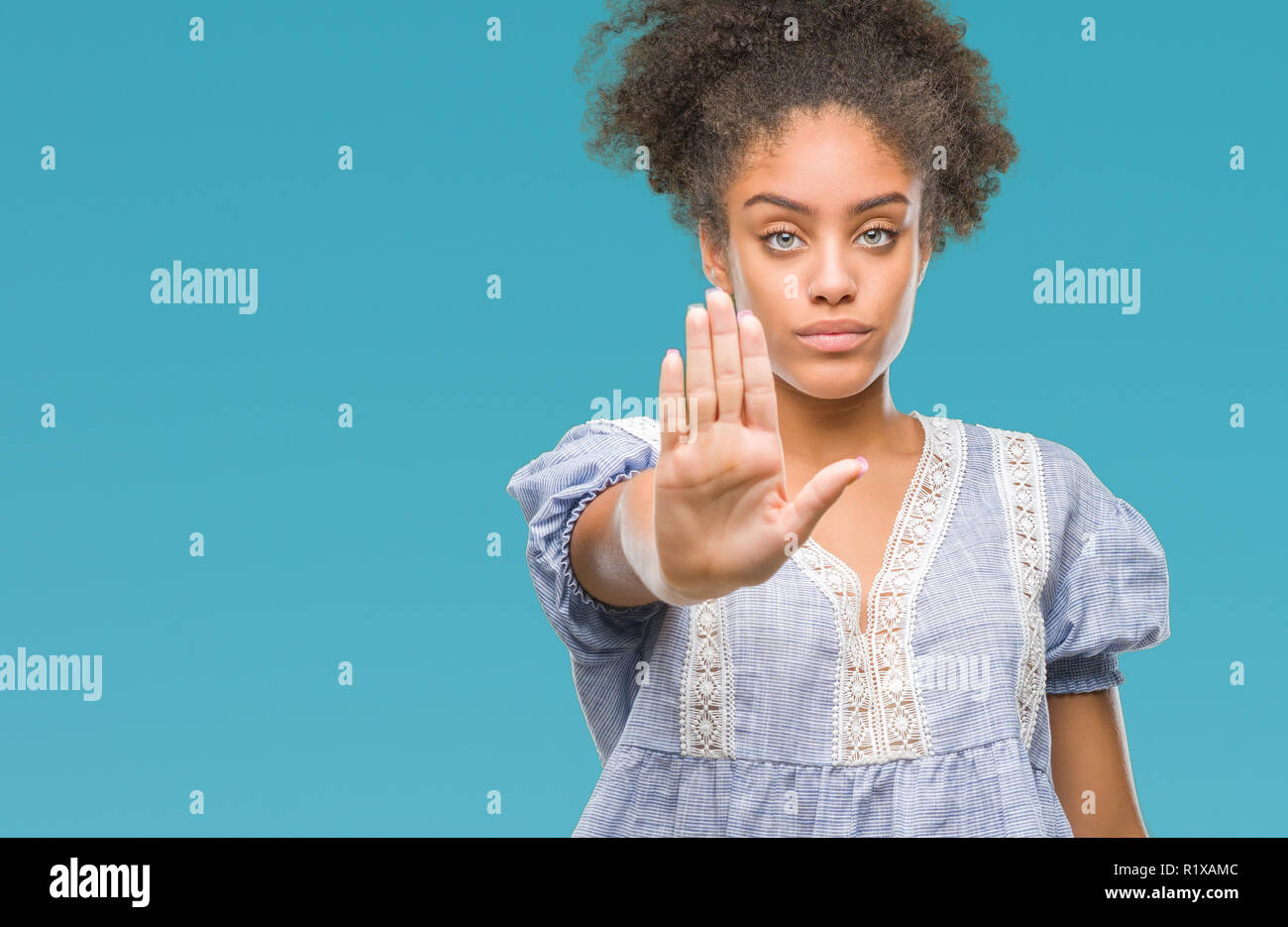 Young afro american woman over isolated background doing stop sing with ...