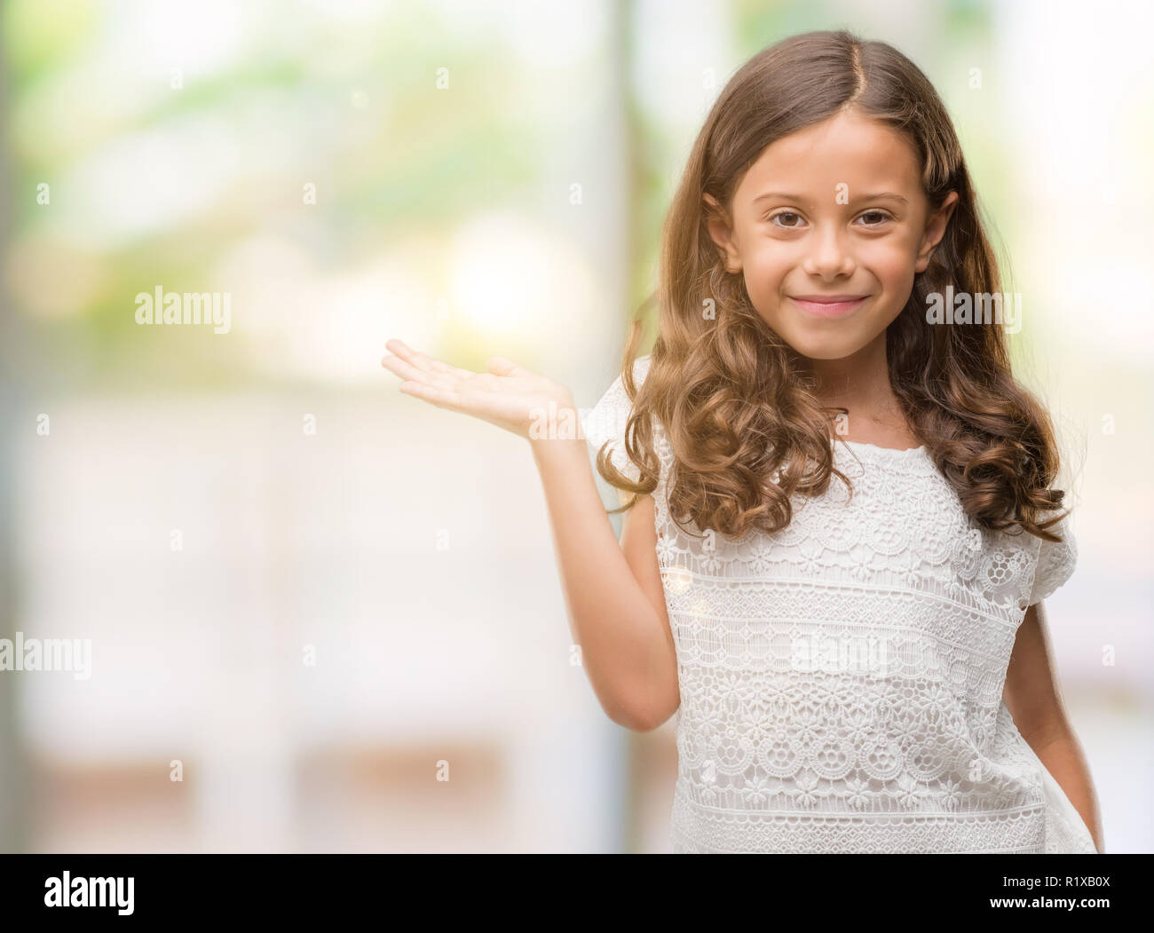 Brunette hispanic girl smiling cheerful presenting and pointing with ...