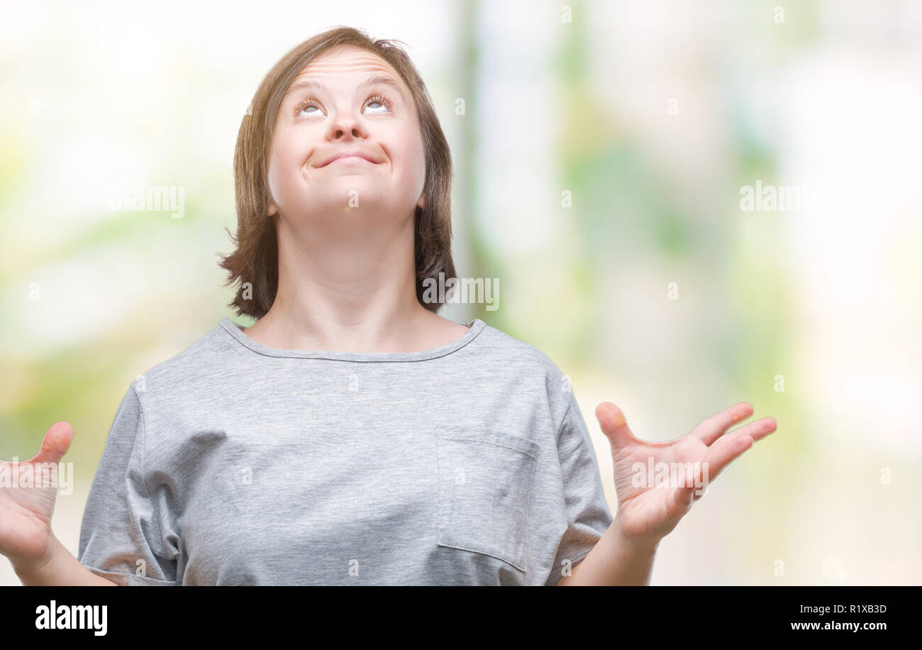 Young adult woman with down syndrome over isolated background crazy and ...
