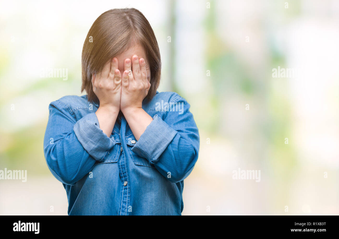 Young adult woman with down syndrome over isolated background with sad ...