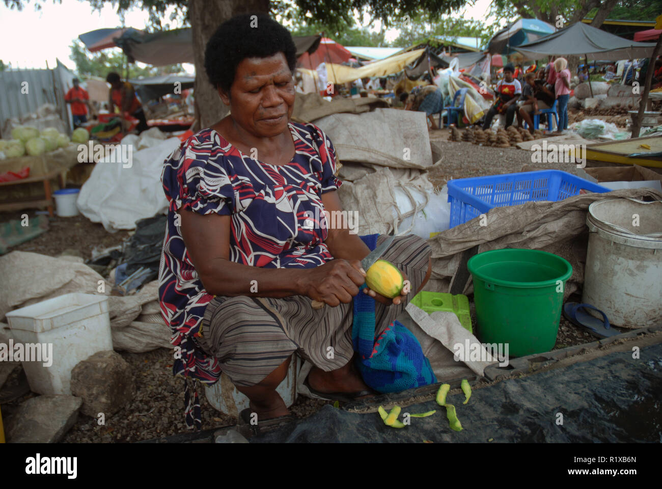 Lady peeling a green mango at Boroko market, Port Moresby, Papua New ...