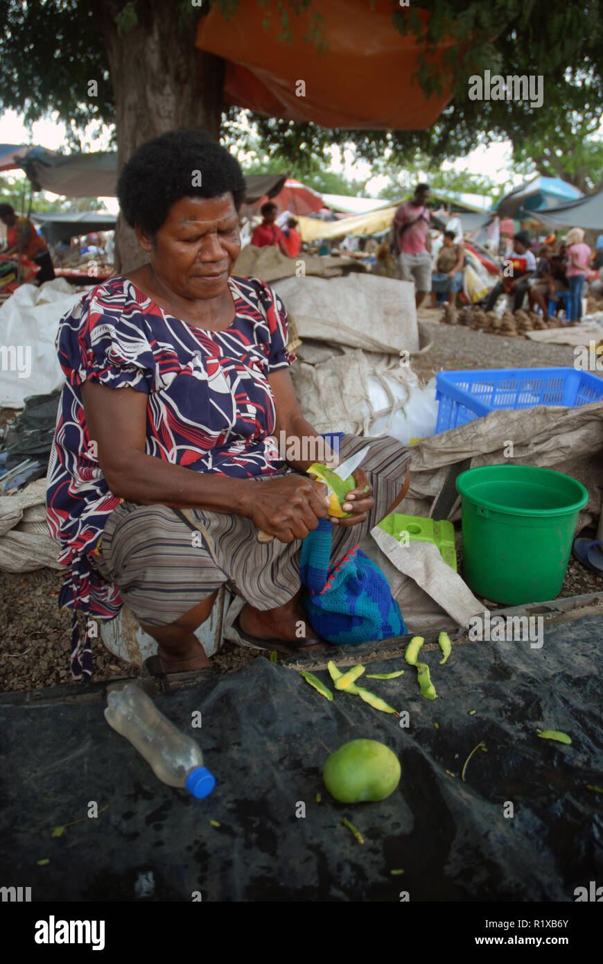 Lady peeling a green mango at Boroko market, Port Moresby, Papua New ...