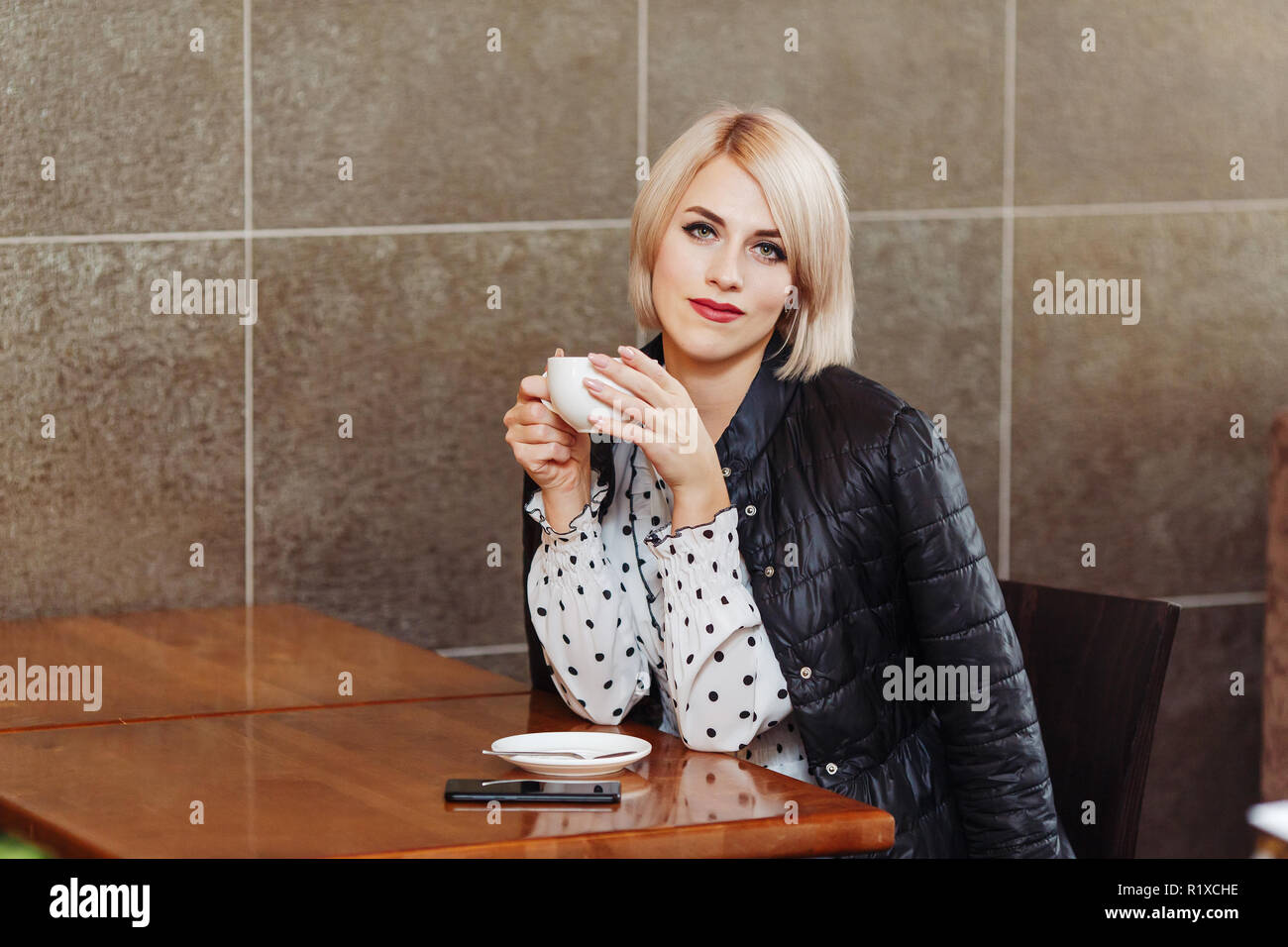 Woman sitting in cafe and drinking hot coffee Stock Photo - Alamy