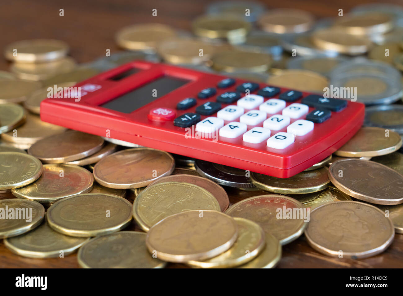 Red Calculator on a background of coins Stock Photo - Alamy