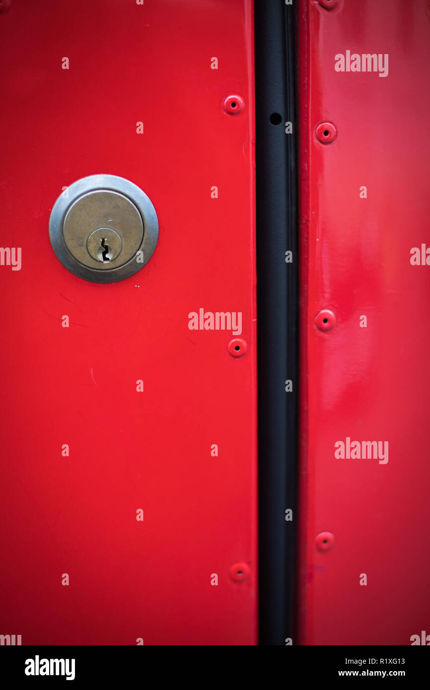 Close up image of a key hole on a red background Stock Photo - Alamy