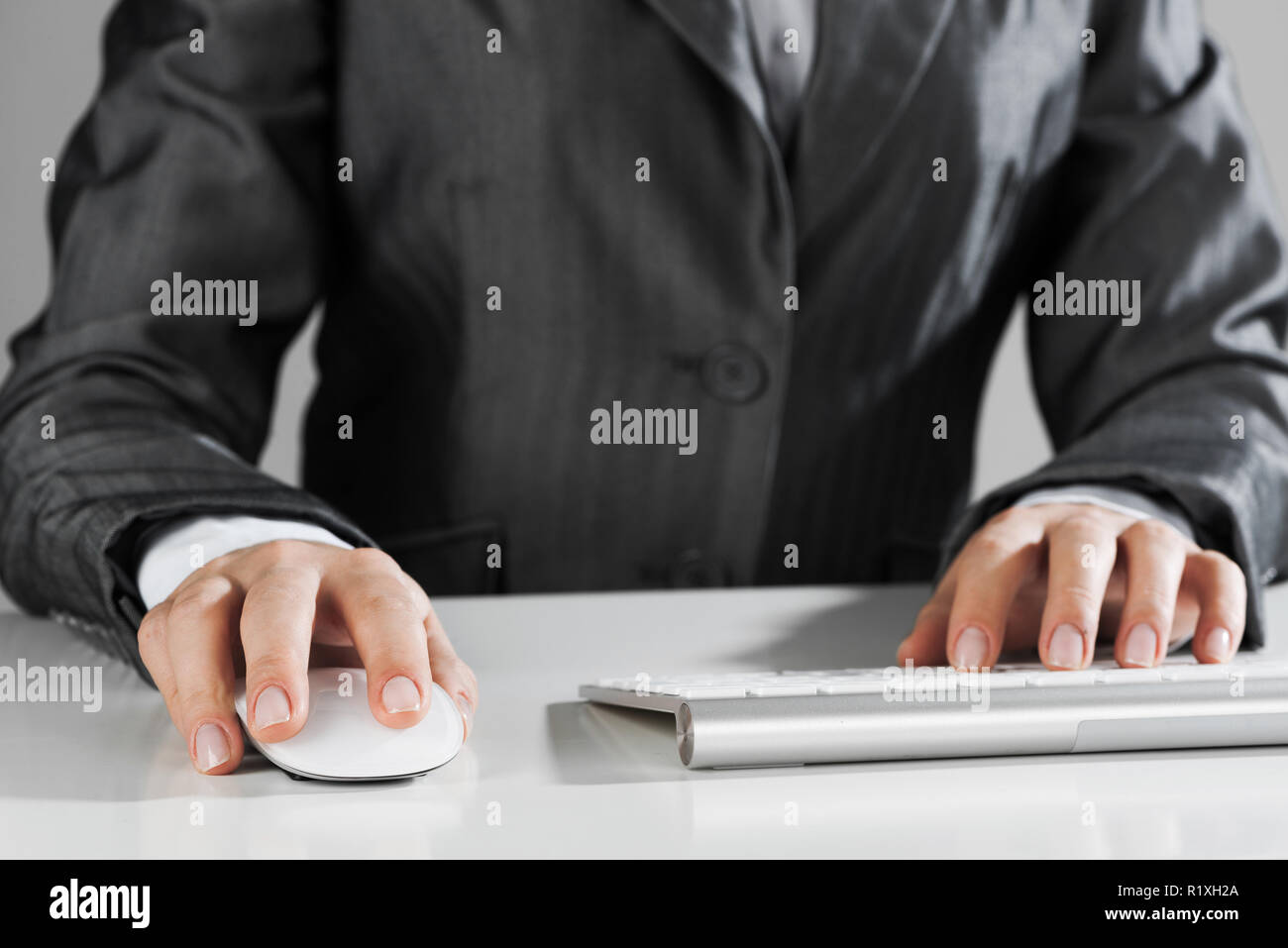 Closeup of businesswoman hand typing on keyboard with mouse on wood ...