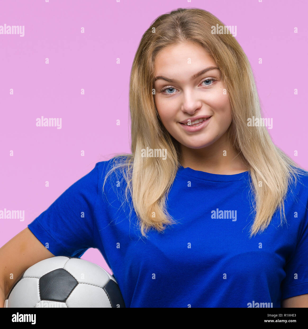 Young caucasian woman holding soccer ball over isolated background with ...