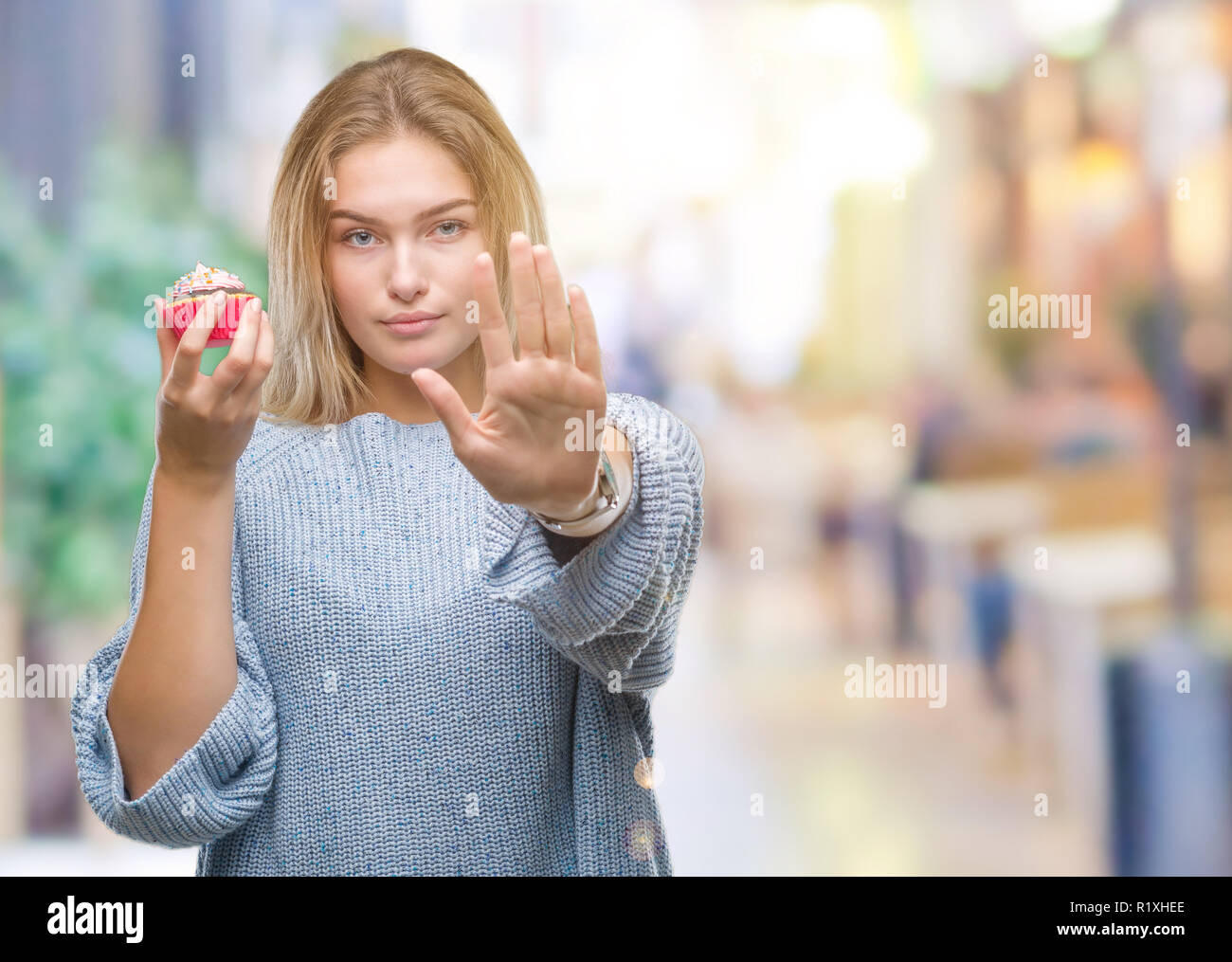Young caucasian woman eating sweet cupcake over isolated background ...