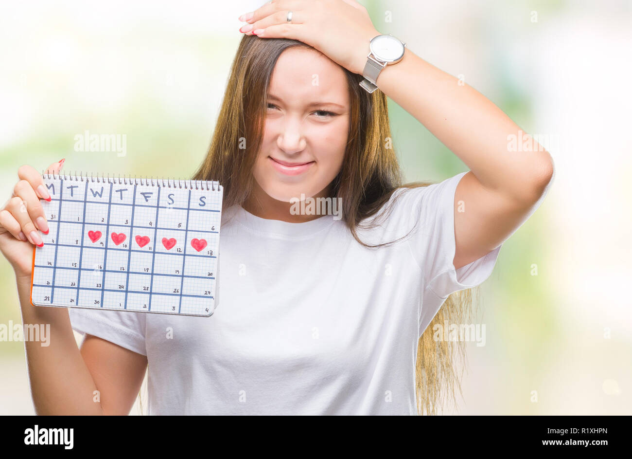 Young caucasian woman holding menstruation calendar over isolated ...