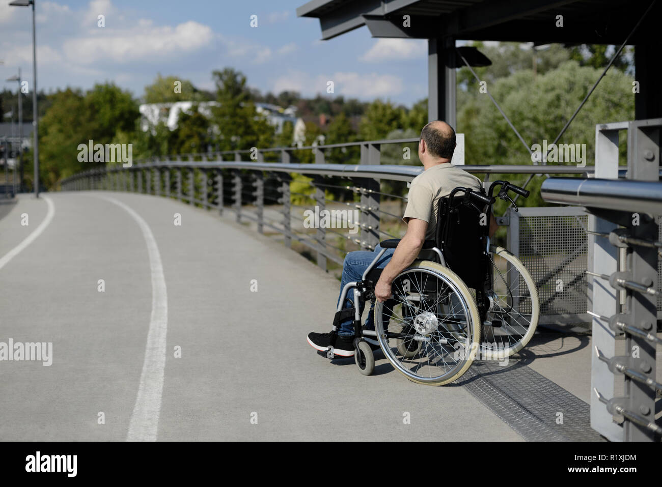 Wheelchair user at barrier free accessible overpass - accessibility ...