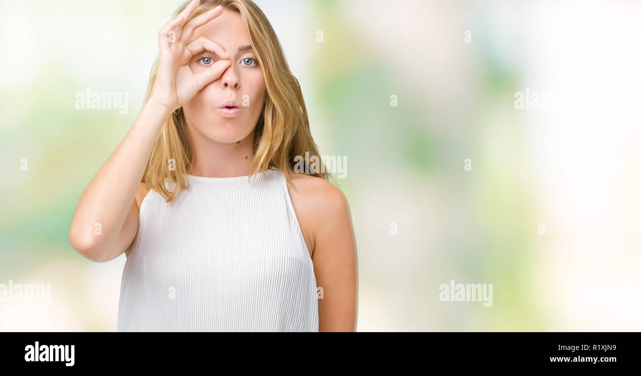 Beautiful young elegant woman over isolated background doing ok gesture ...