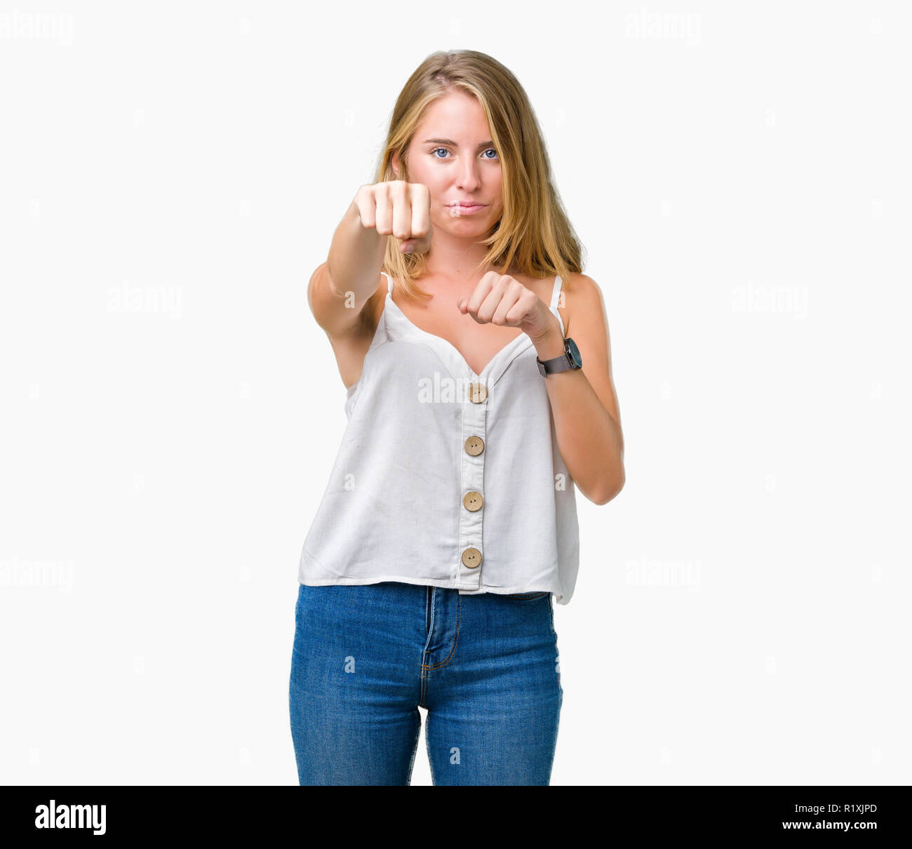Beautiful young woman over isolated background Punching fist to fight ...