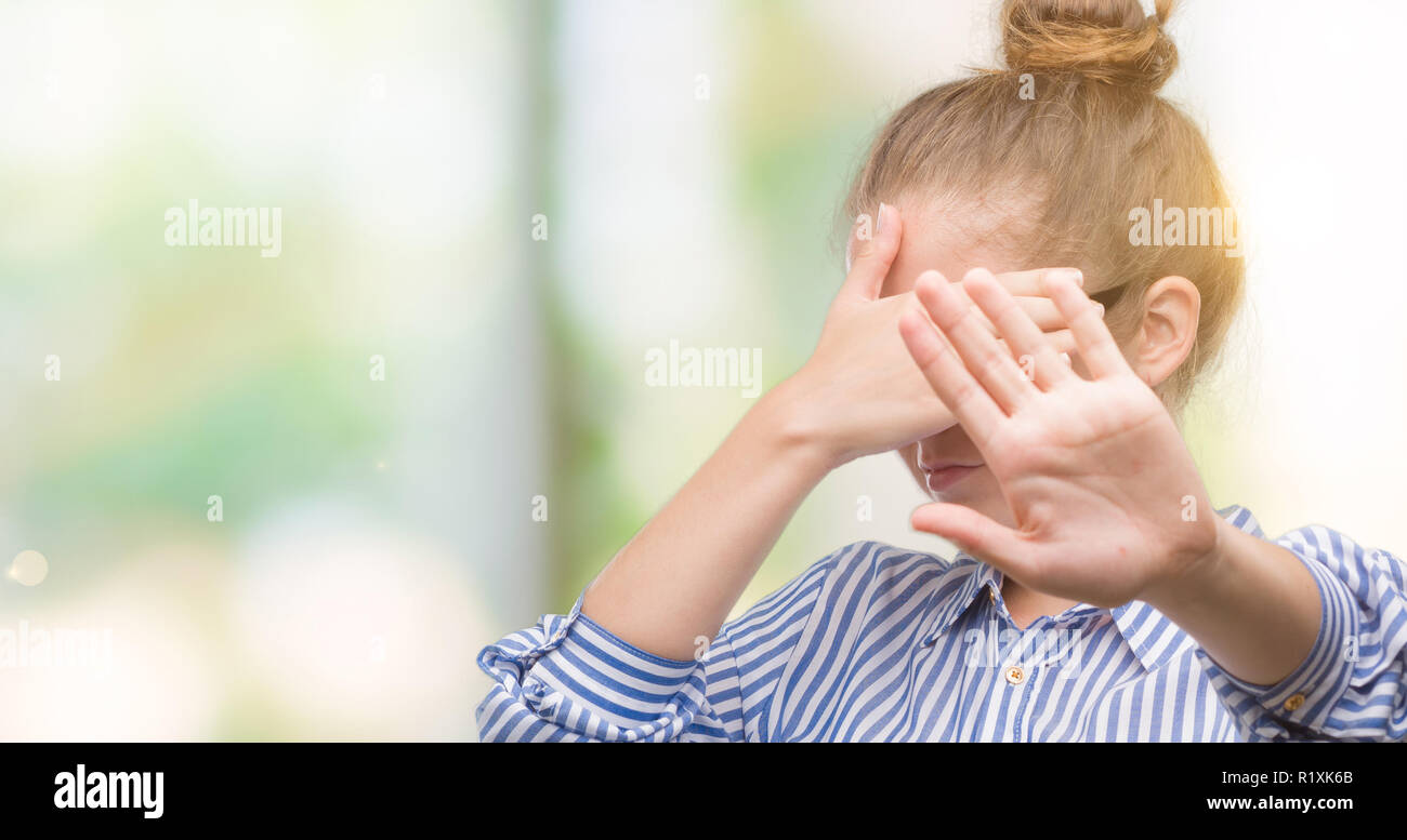 Young blonde business woman covering eyes with hands and doing stop ...