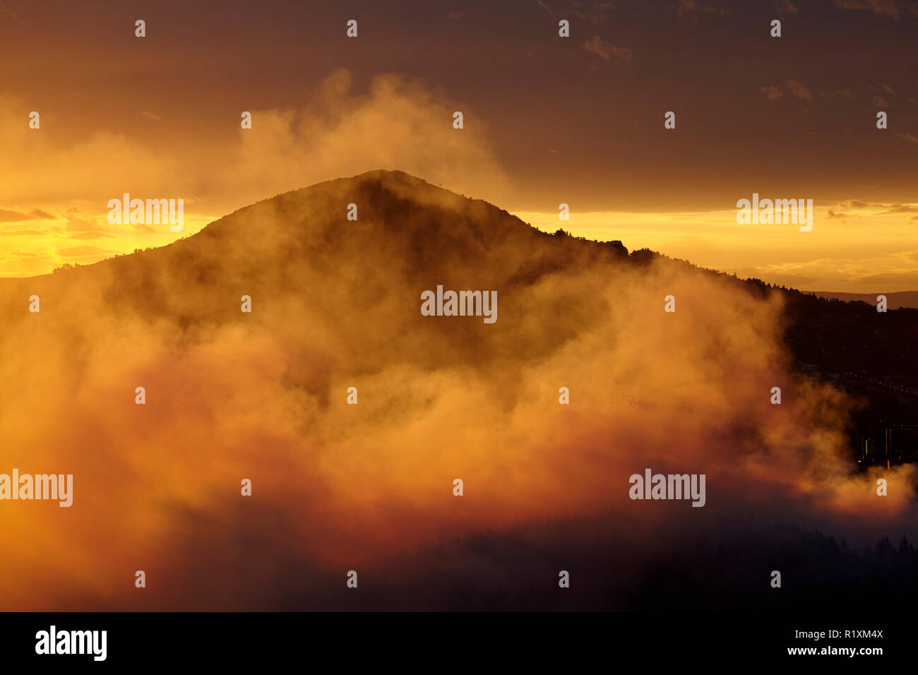 Saddle Hill and smokey sunset from fire at Burnside, Dunedin, South ...