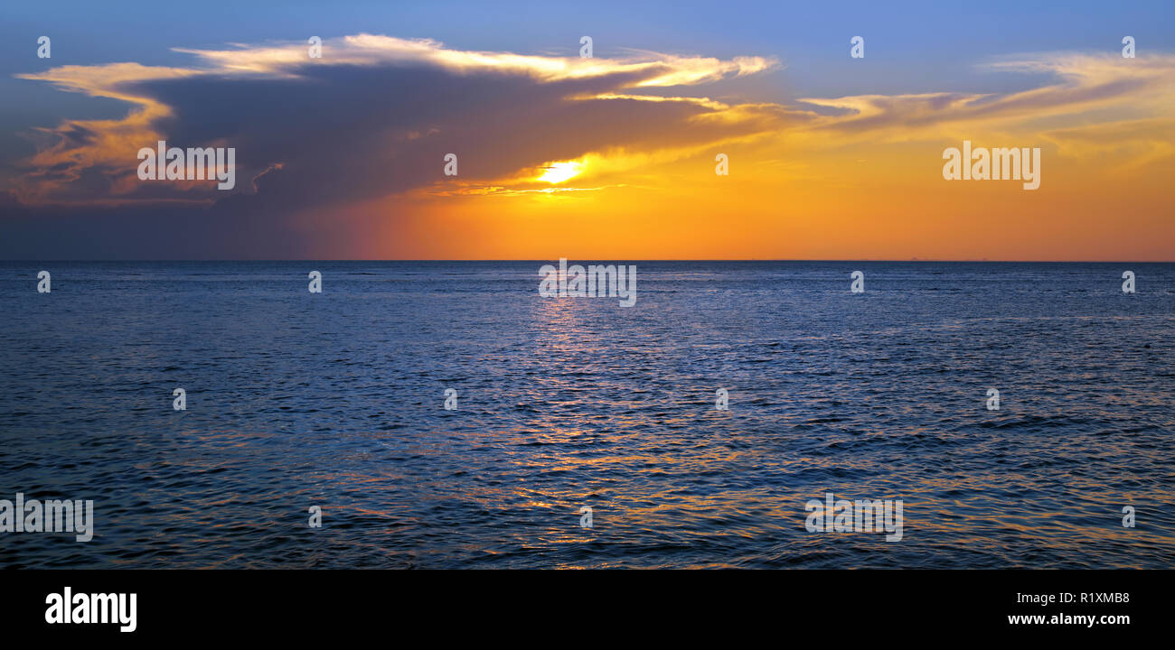 Colorful empty seascape with shiny sea over cloudy sky and sun during ...
