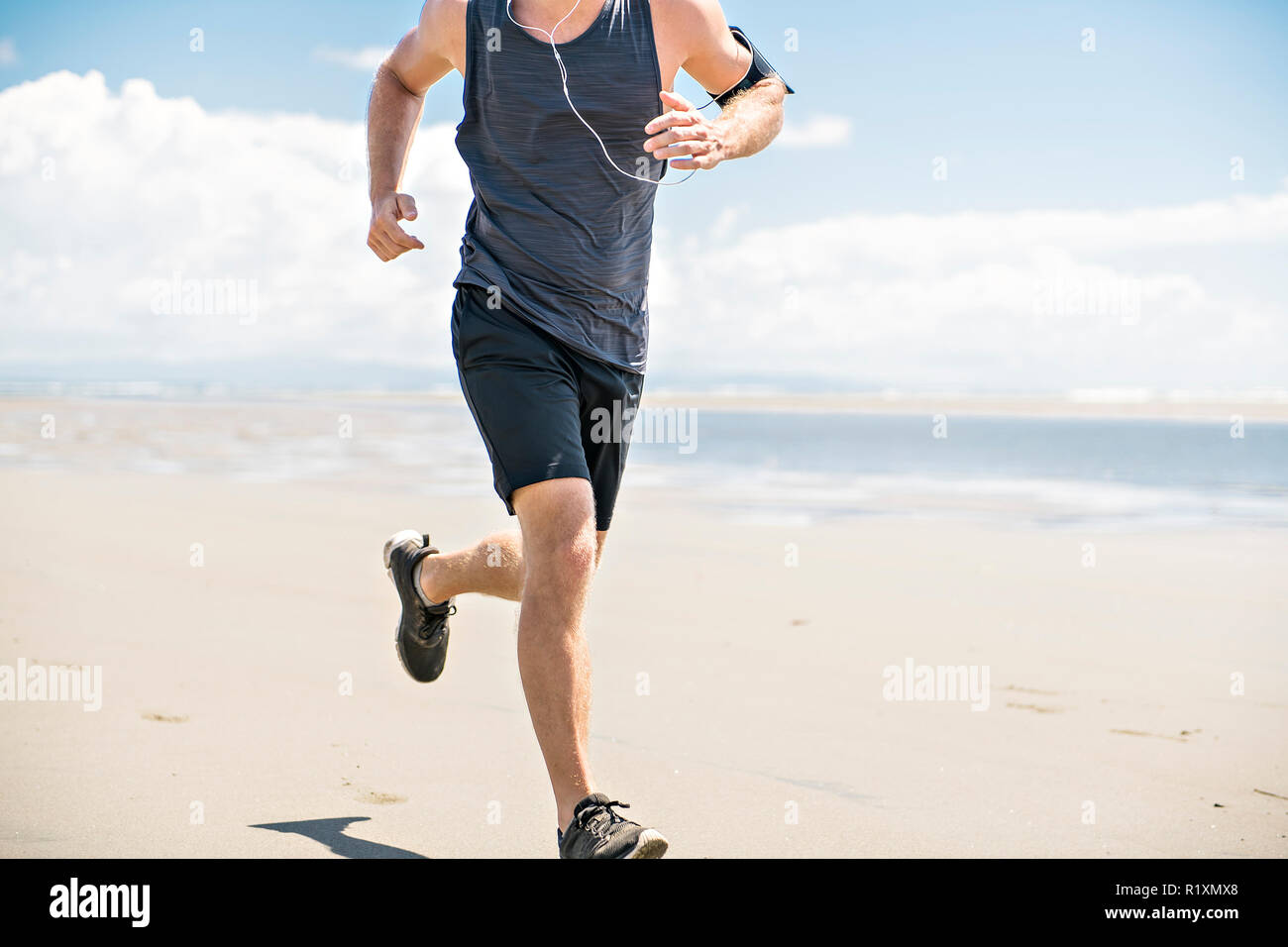 Men jogging on day time on the beach Stock Photo - Alamy