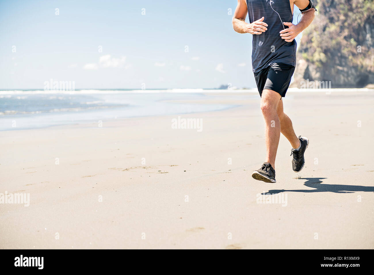 Men jogging on day time on the beach Stock Photo - Alamy