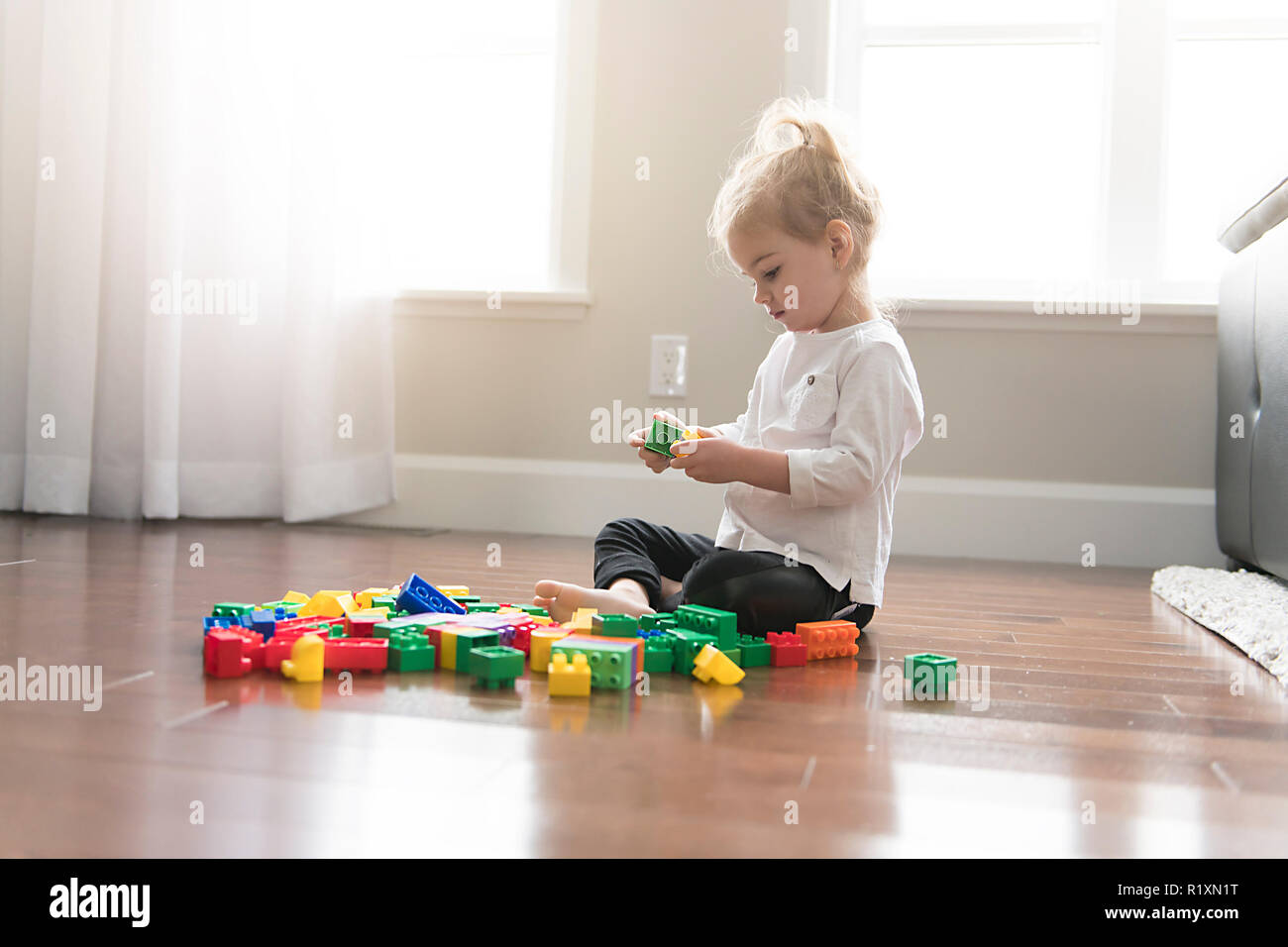 A child girl building from toy blocks at home Stock Photo - Alamy