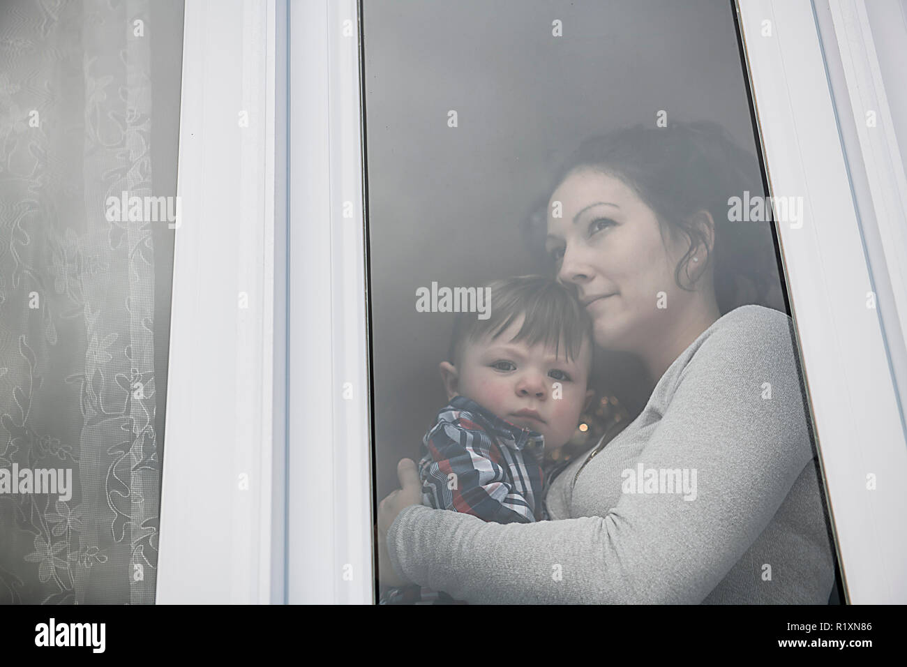 A mother and toddler son looking out window outside Stock Photo - Alamy