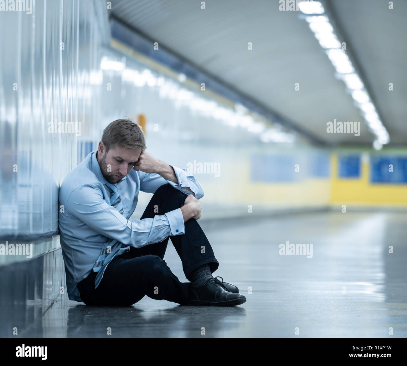 Young jobless business man suffering depression sitting on ground ...