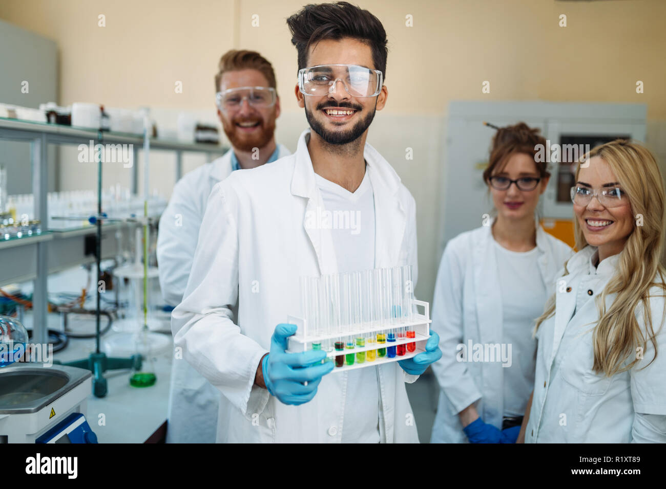 Group of young successful scientists posing for camera Stock Photo - Alamy