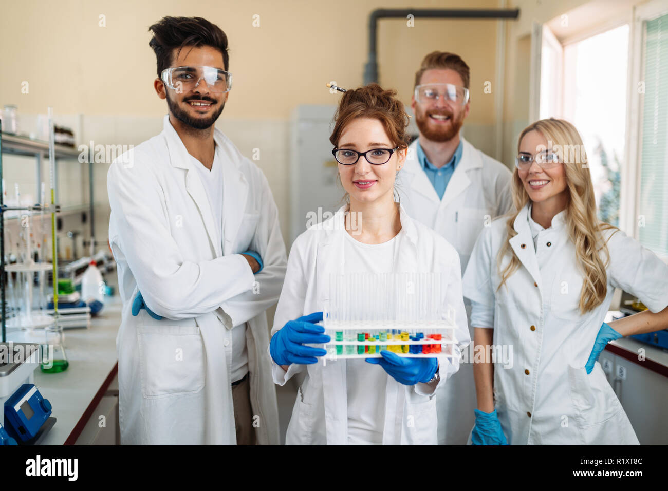 Group of young successful scientists posing for camera Stock Photo - Alamy