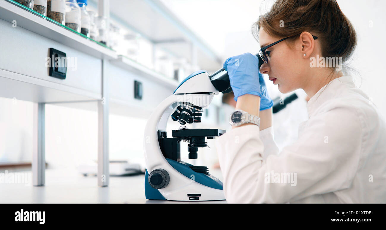 Female scientist looking through microscope hi-res stock photography ...