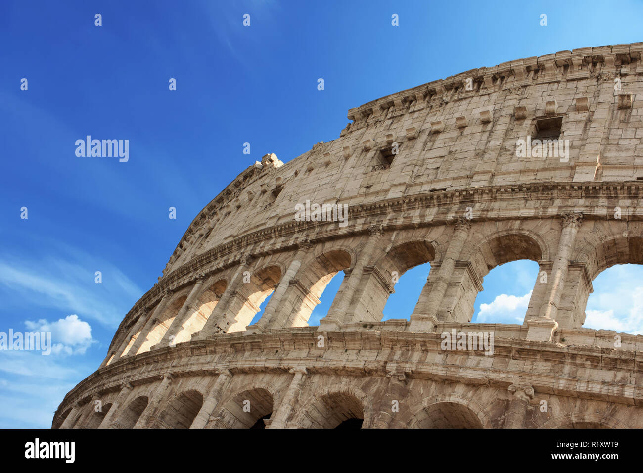 Scenic detail of the arches of the Colosseum. Marble ruins over a blue ...