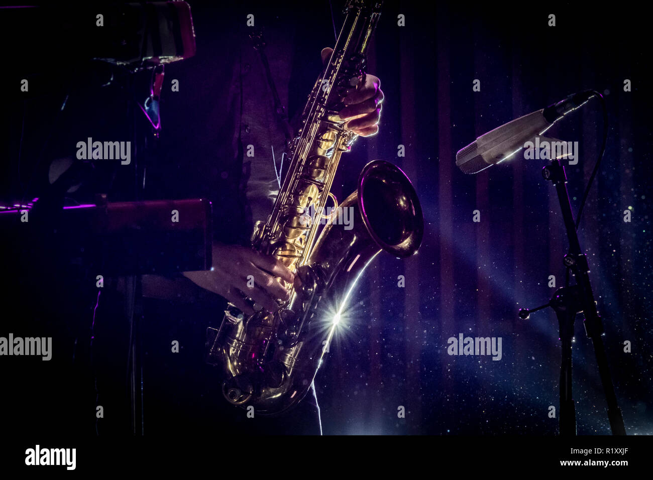 A musician is playing a saxophone during a live concert at a music ...