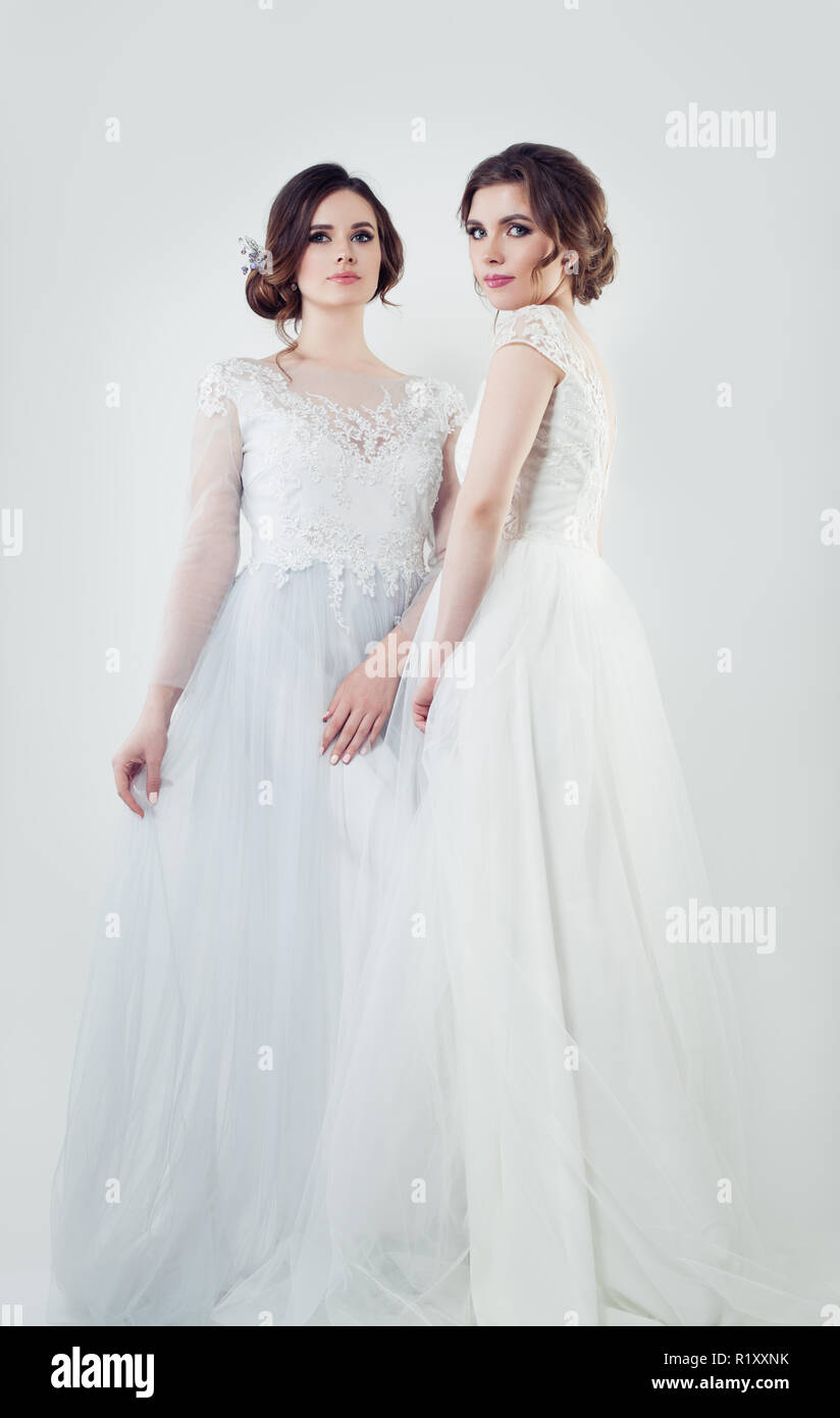 Two charming bride portrait. Perfect women in white wedding dress ...