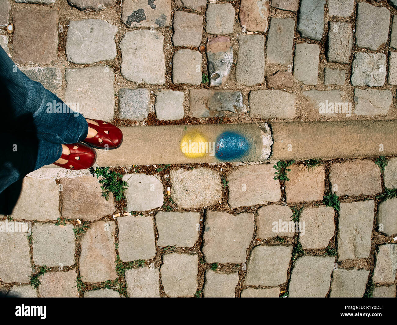 Legs and feet of a woman standing on the stone floor. Woman wearing ...