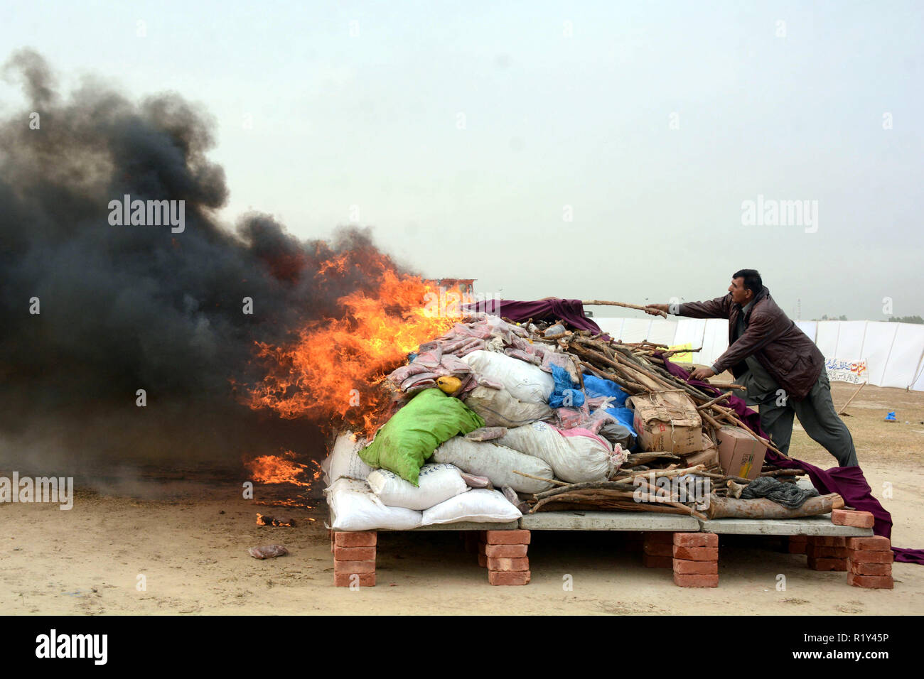 Lahore. 14th Nov, 2018. An Anti Narcotics Force (ANF) official burns a ...
