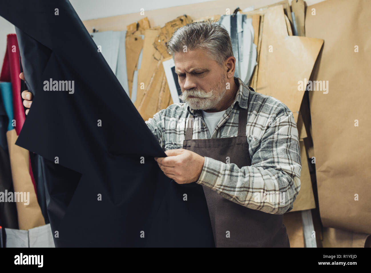 concentrated handbag craftsman looking at leather in workshop Stock ...
