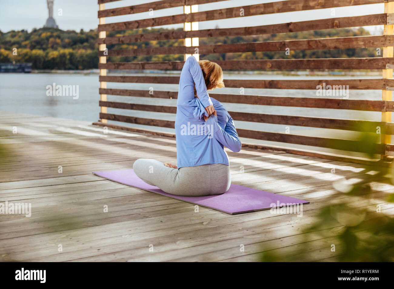 Flexible woman stretching the back muscles while doing yoga Stock Photo ...