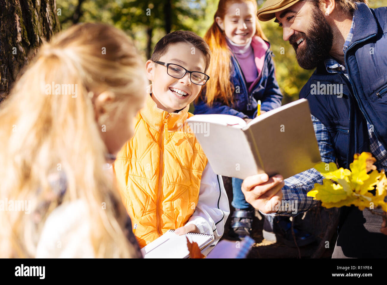 Joyful happy boy looking into the book Stock Photo - Alamy