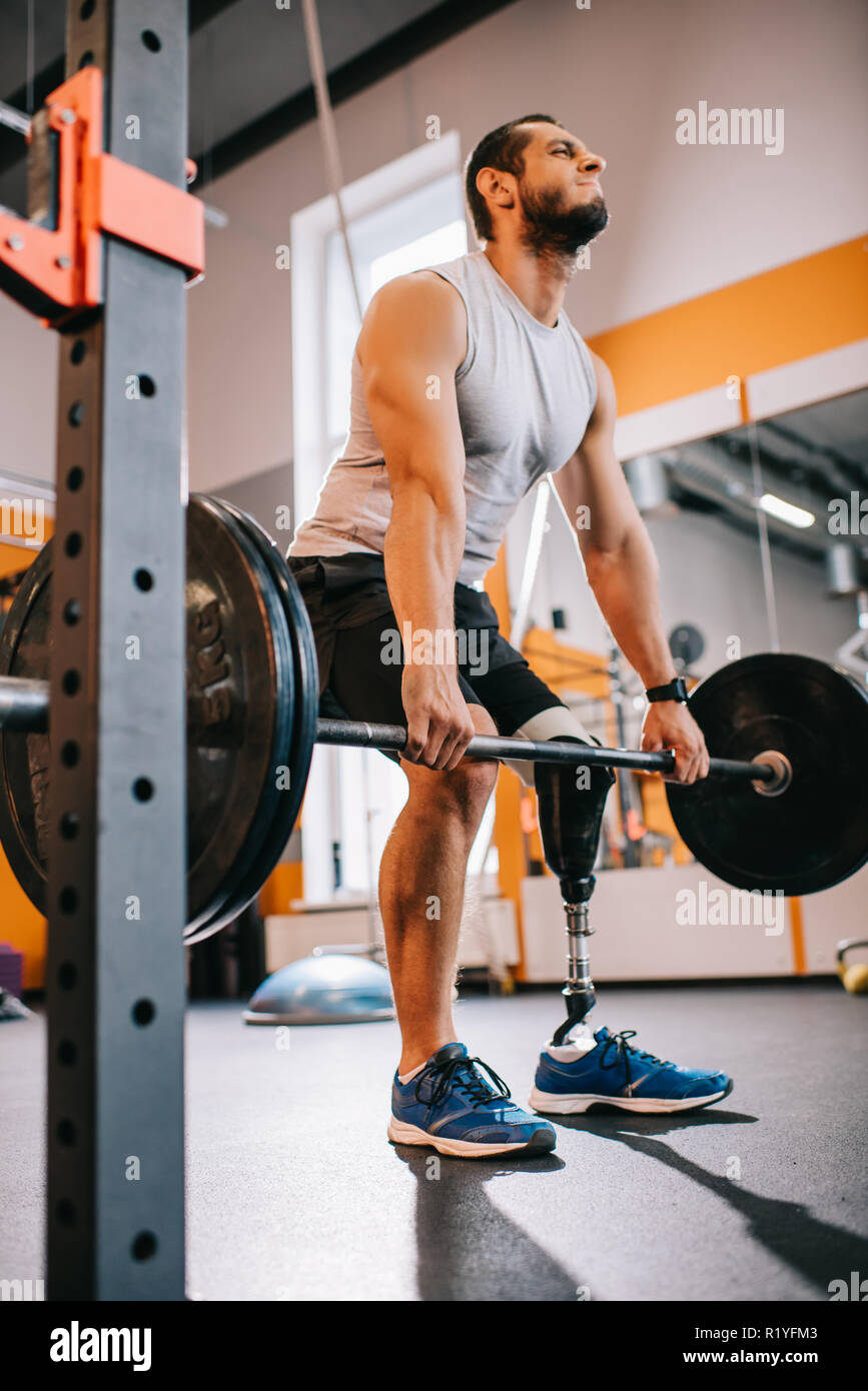 bottom view of young sportsman with artificial leg working out with ...