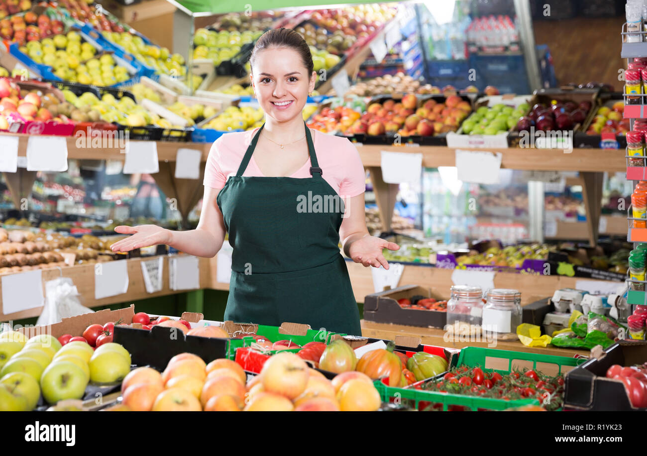 Portrait of young confident saleswoman of vegetable store standing ...