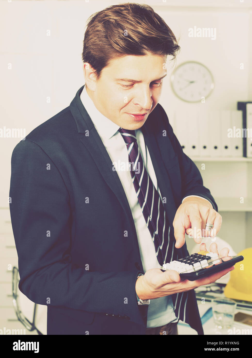 Young man worker calculating in the office on the computer Stock Photo ...